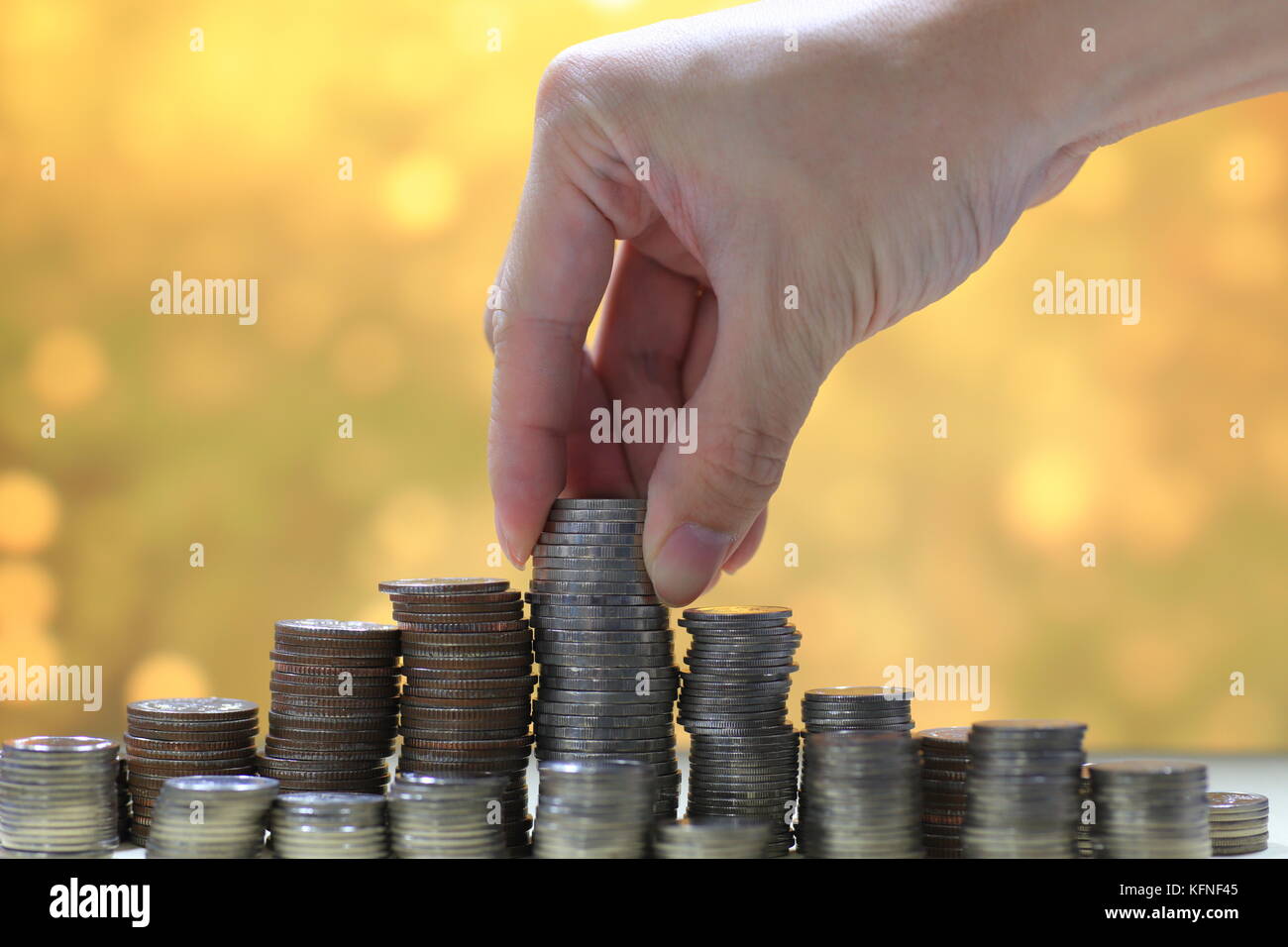 Coin stack row hand holding coin making a tower. Yellow gold circular ...