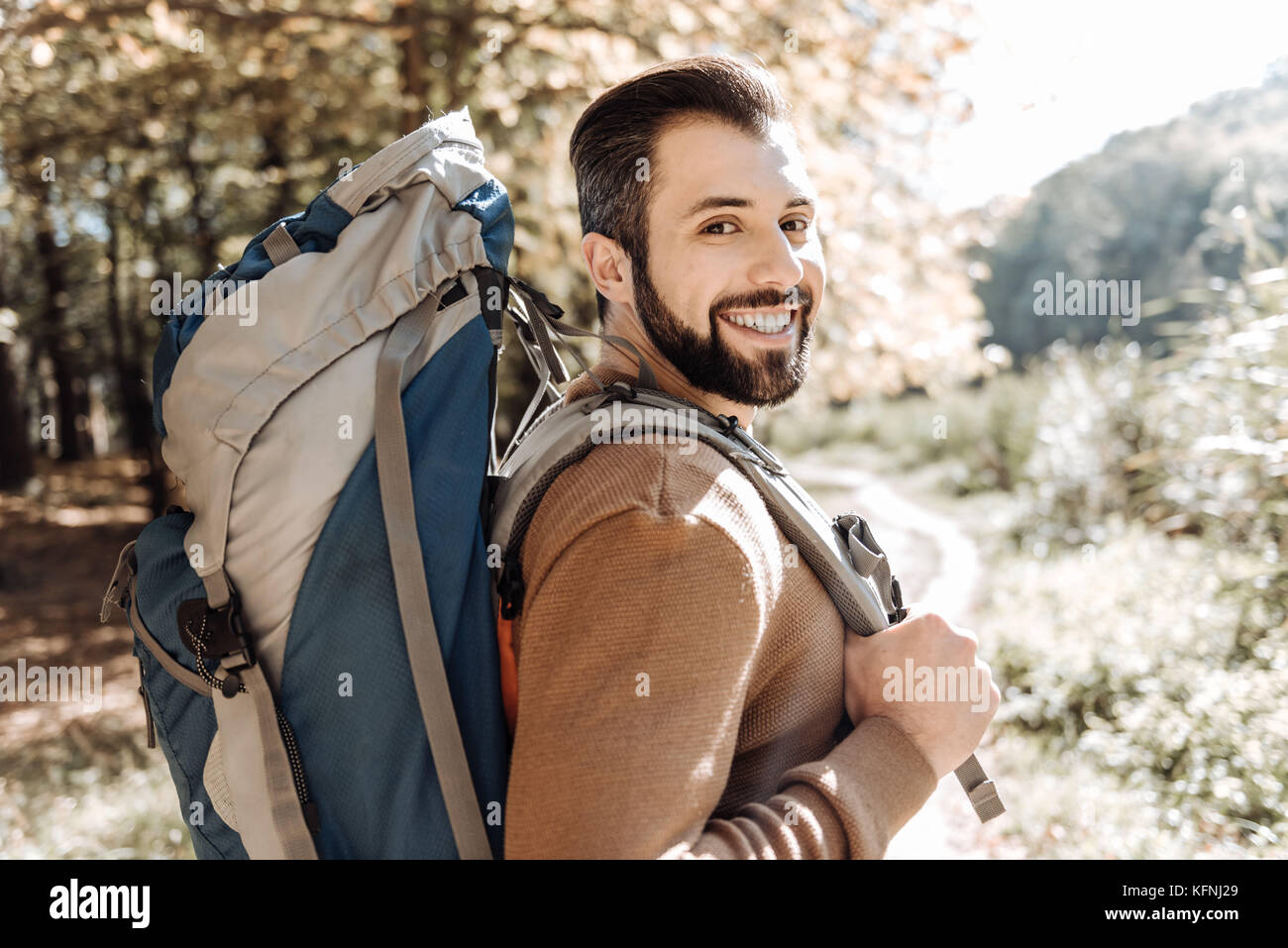 Cheerful handsome man caring a rucksack Stock Photo - Alamy