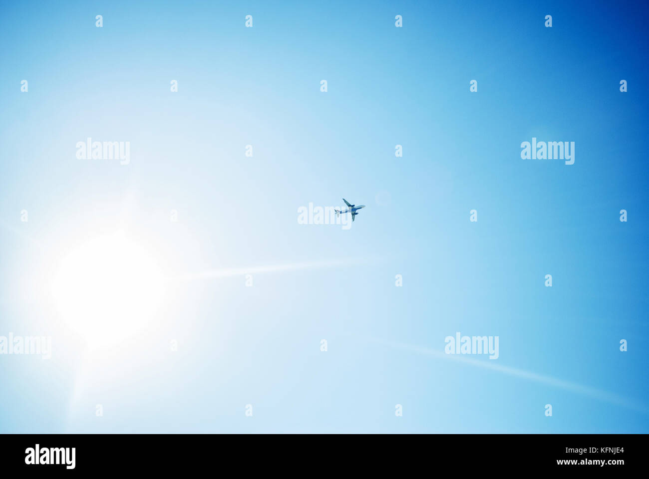 Plane crossing a cloud vignette and sun Stock Photo - Alamy