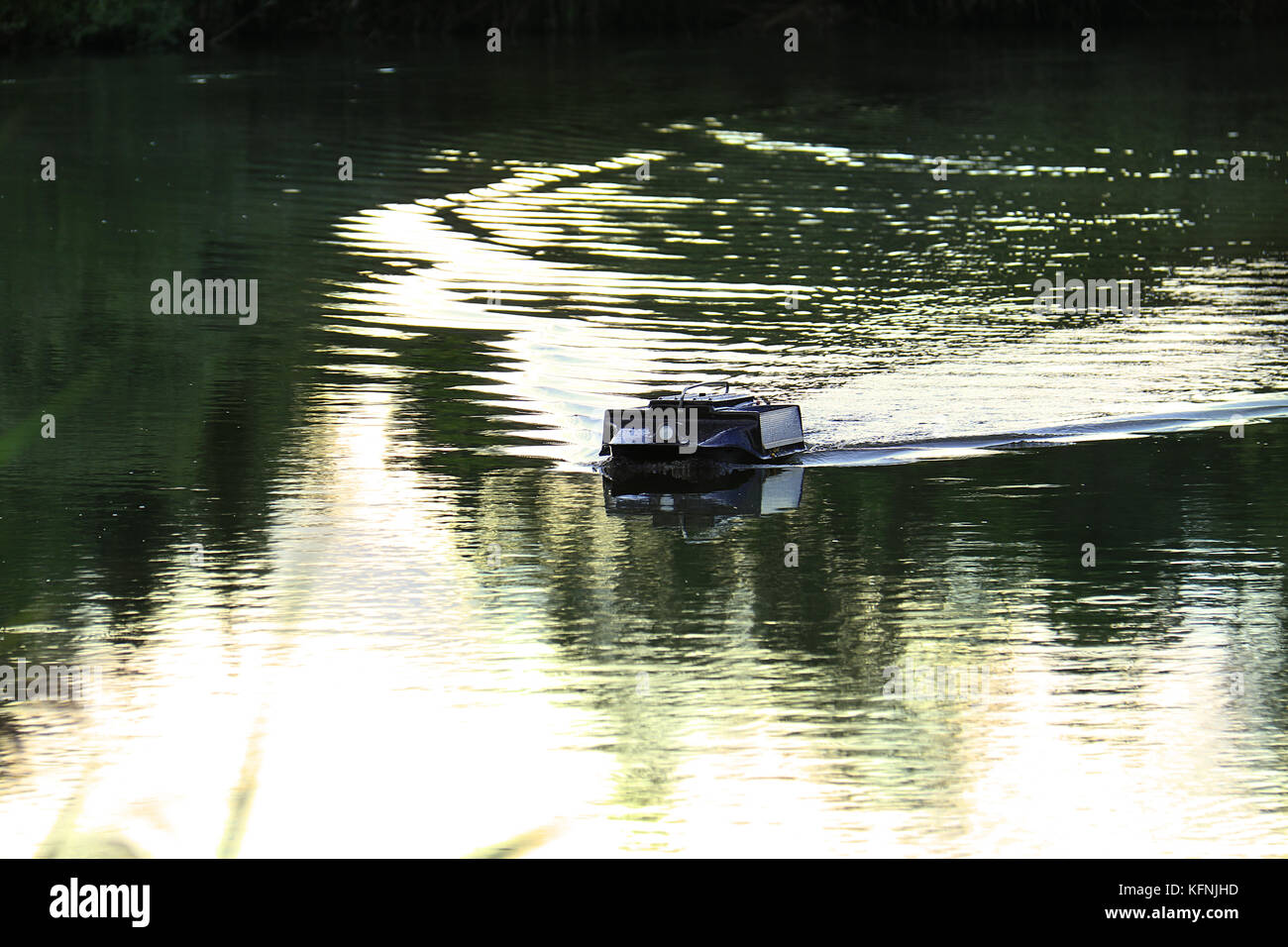 A remote controlled feeder boat in a lake used in recreational fishing ...