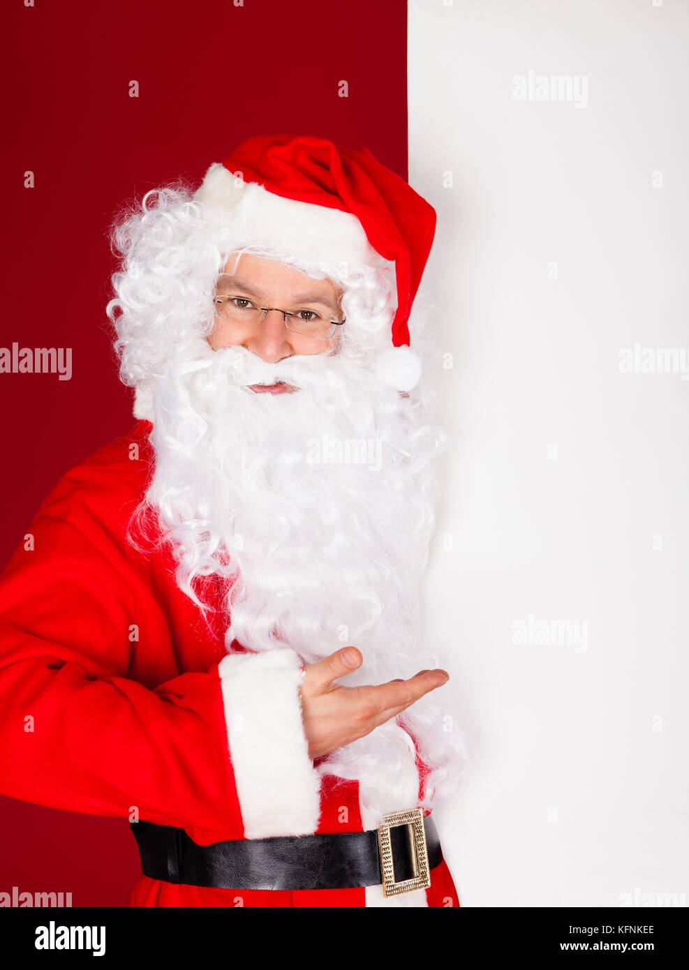 Portrait of a santa holding blank placard over red background Stock ...