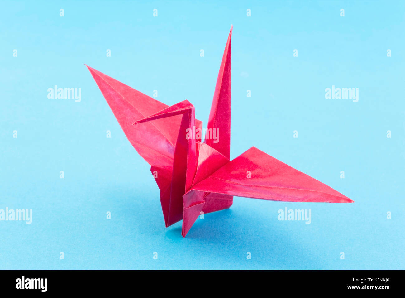 Red Origami Crane on Blue Background Stock Photo - Alamy