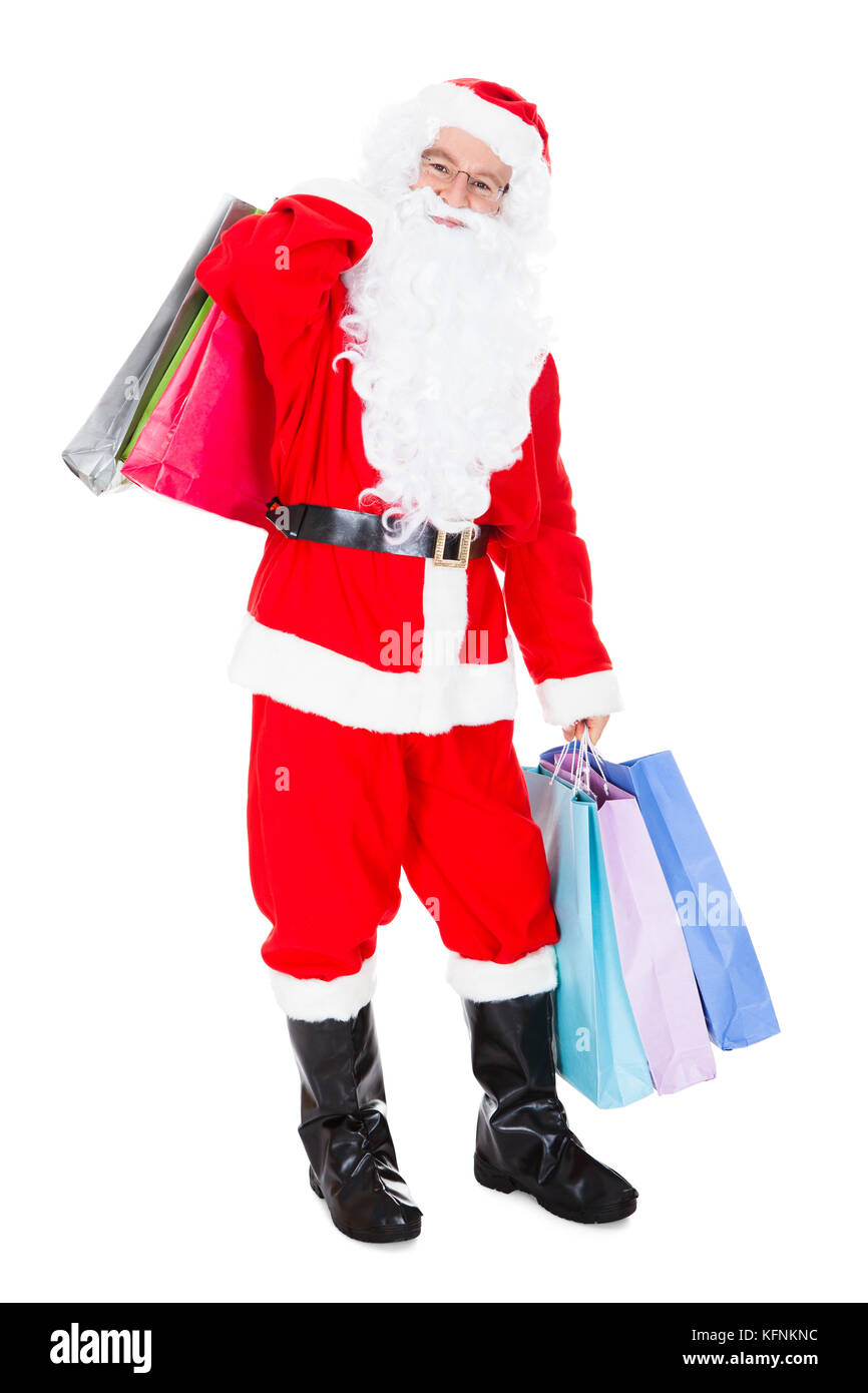 Portrait of santa holding shopping bag over white background Stock ...