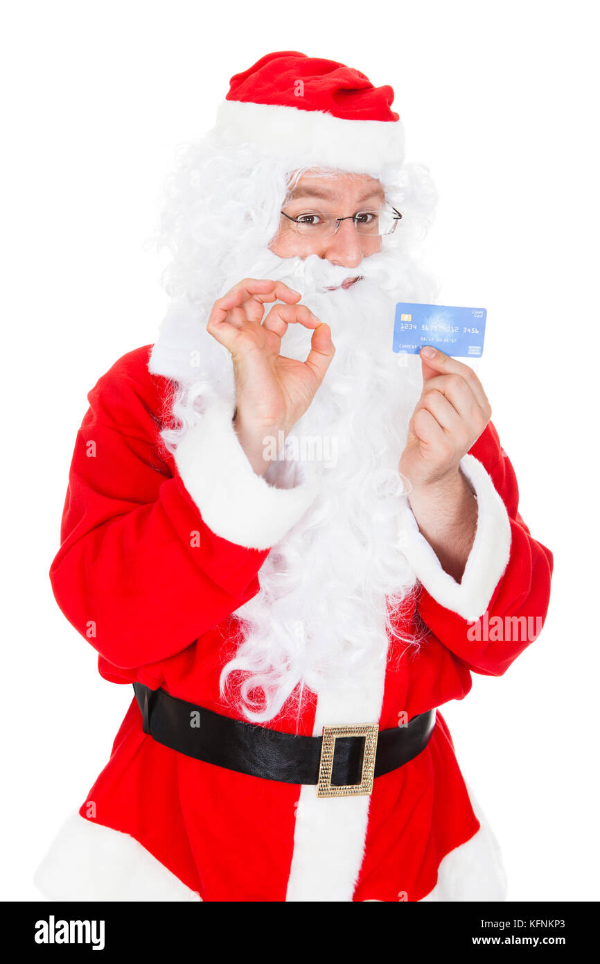 Portrait of santa pointing at credit card over white background Stock ...