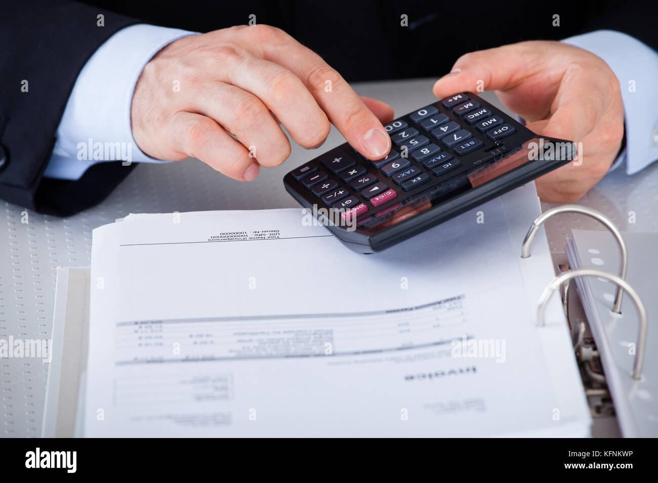 Happy Mature Businessman Calculating Finance With Calculator At Desk ...