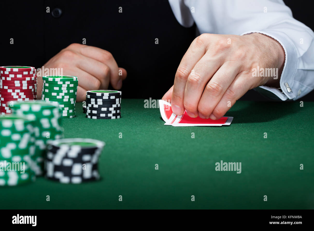 Close-up of a hand of poker player with cards and chips Stock Photo - Alamy