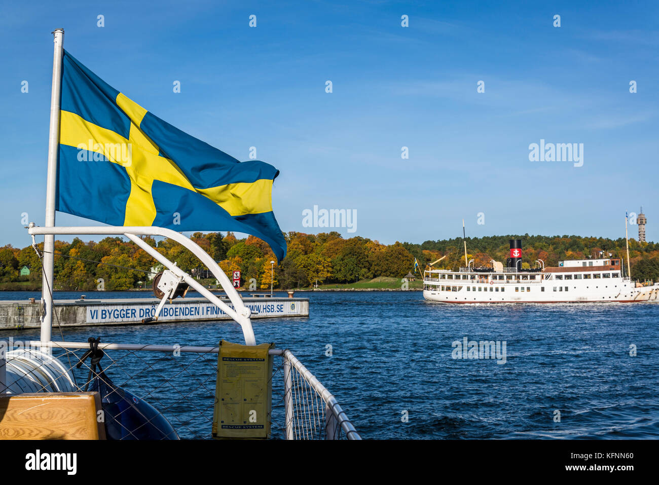 Swedish flag on a boat and Djurgarden island in the background ...