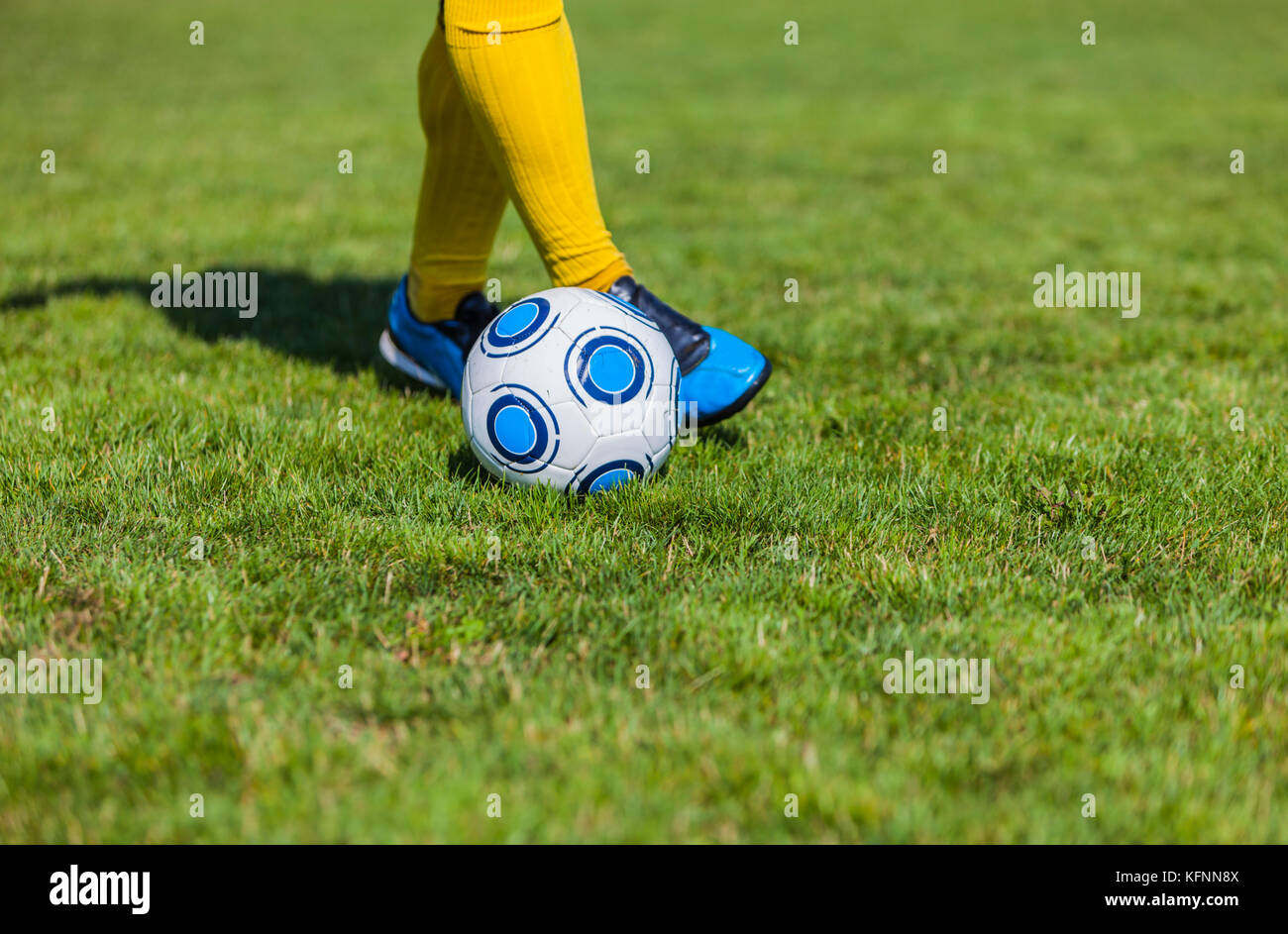 Close-up image of the feet of a soccer player dribbling. Focus on the ...