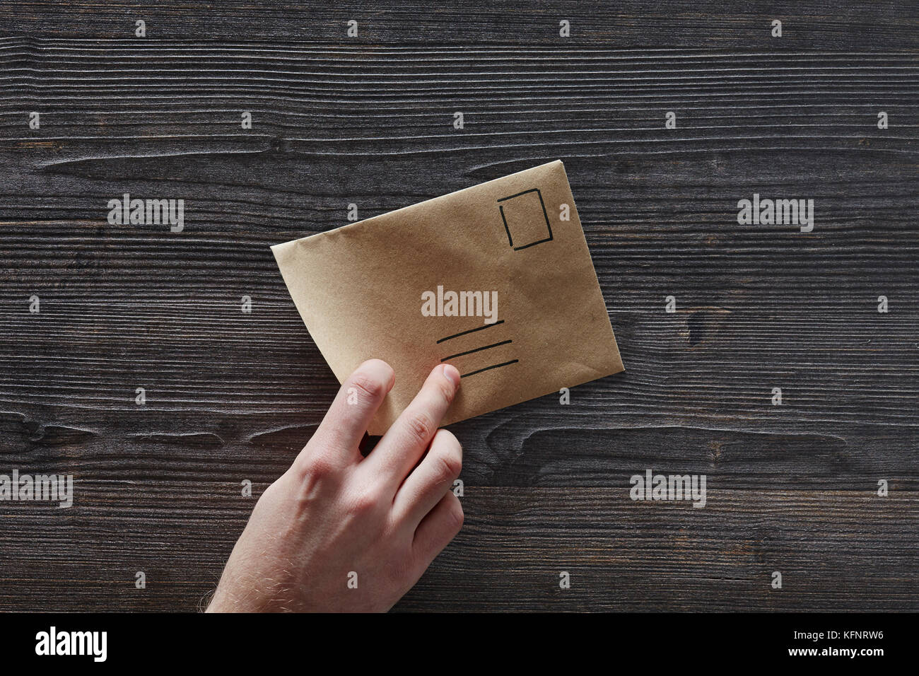 hand picking up unadressed letter Stock Photo - Alamy
