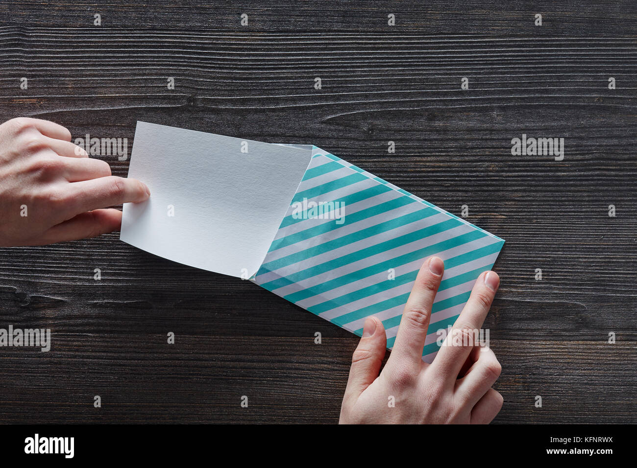 hands opening striped letter on dark wooden surface Stock Photo - Alamy