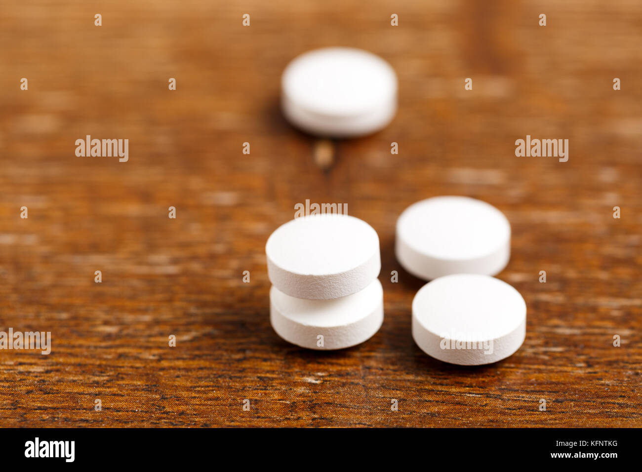 Round white medicine pills on green background Stock Photo - Alamy