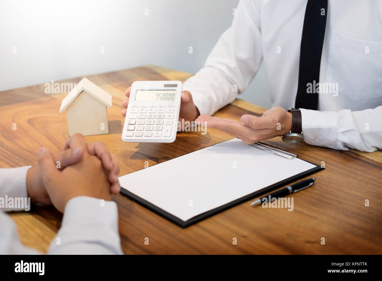 Real estate agent showing the purchase price on a calculator to ...