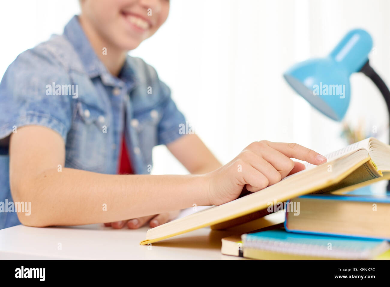 student boy reading book at home table Stock Photo - Alamy
