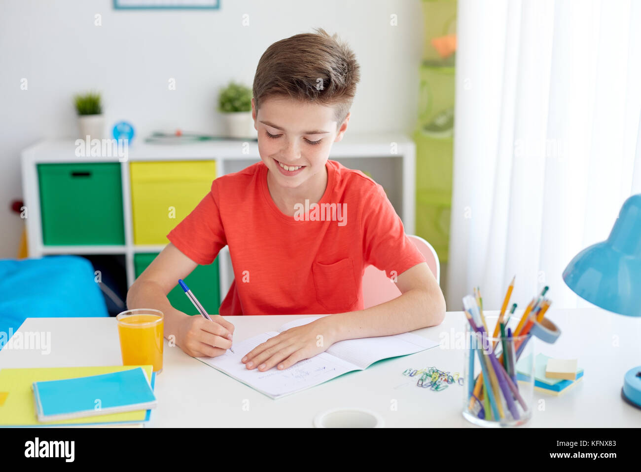 happy student boy writing to notebook at home Stock Photo - Alamy