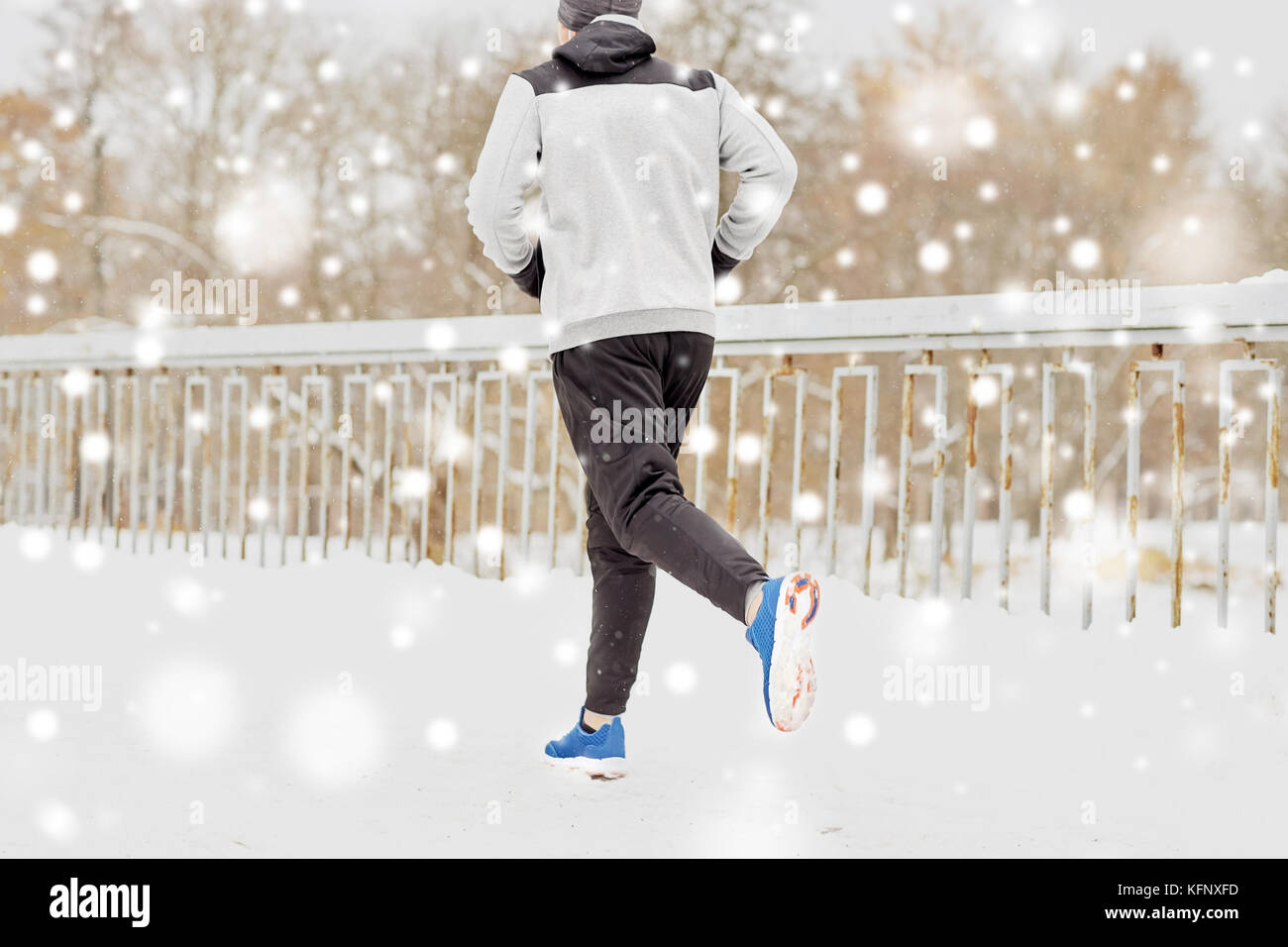 man running along snow covered winter bridge road Stock Photo - Alamy