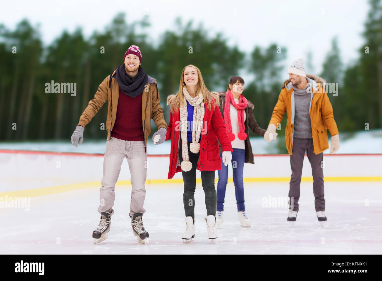 friends holding hands on outdoor skating rink Stock Photo - Alamy