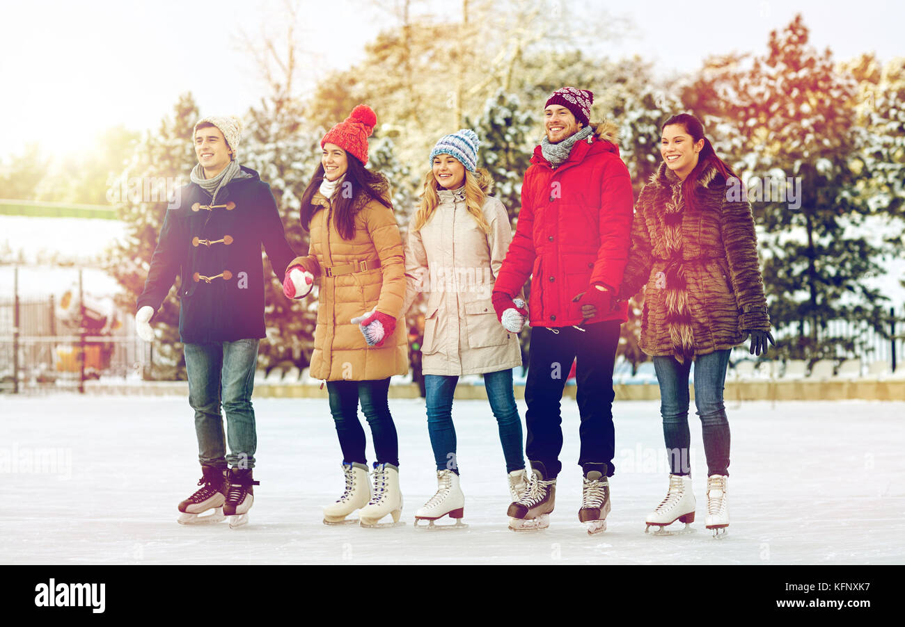 happy friends ice skating on rink outdoors Stock Photo - Alamy