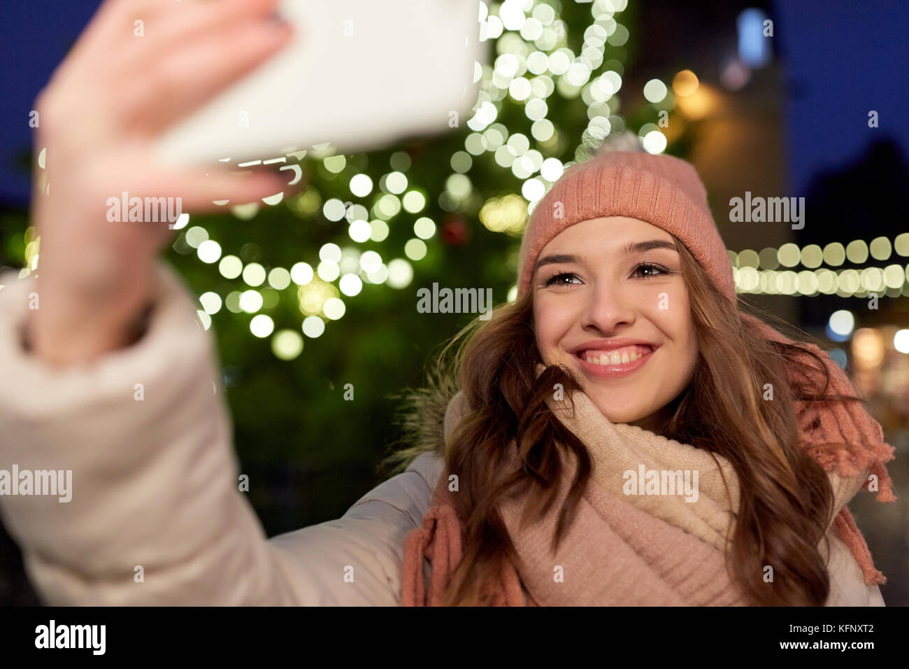 young woman taking selfie over christmas tree Stock Photo - Alamy