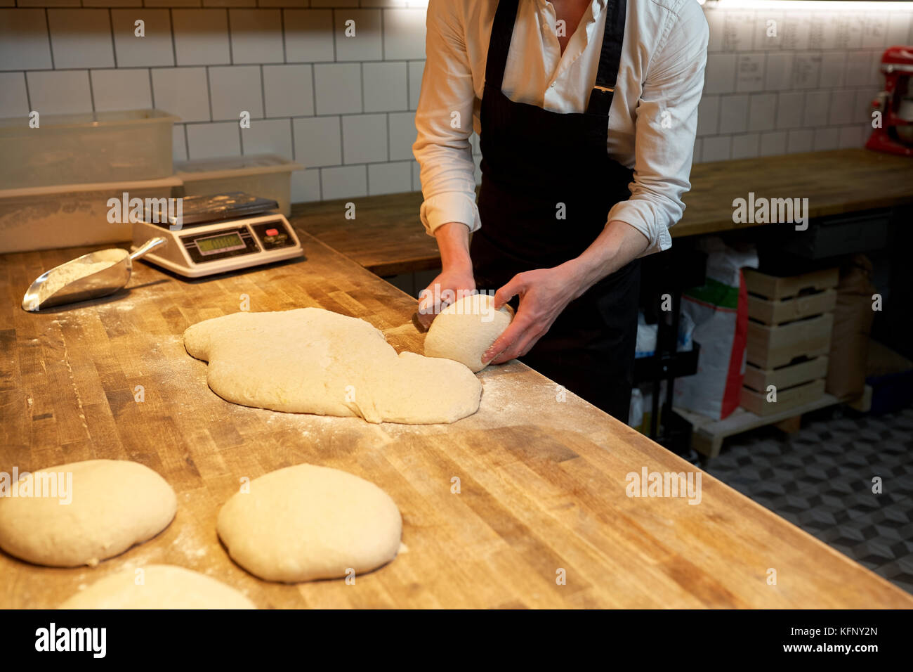 baker portioning dough with bench cutter at bakery Stock Photo - Alamy