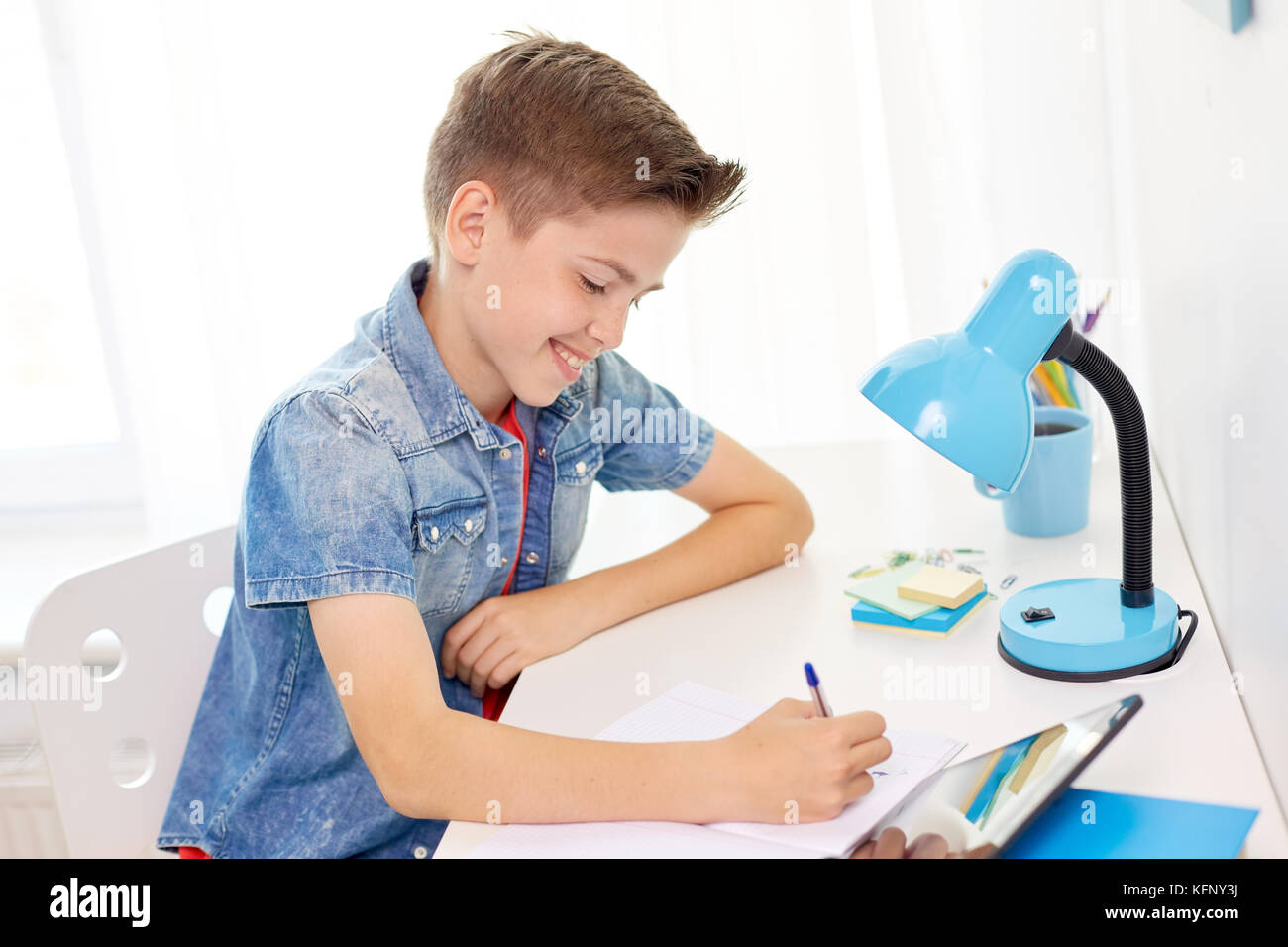 happy student boy writing to notebook at home Stock Photo - Alamy