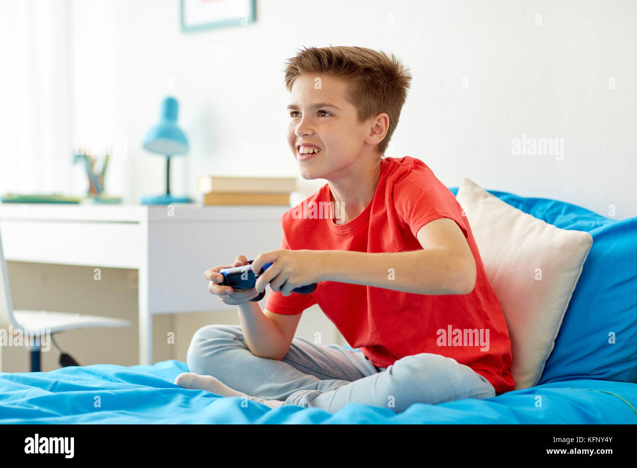 happy boy with gamepad playing video game at home Stock Photo - Alamy