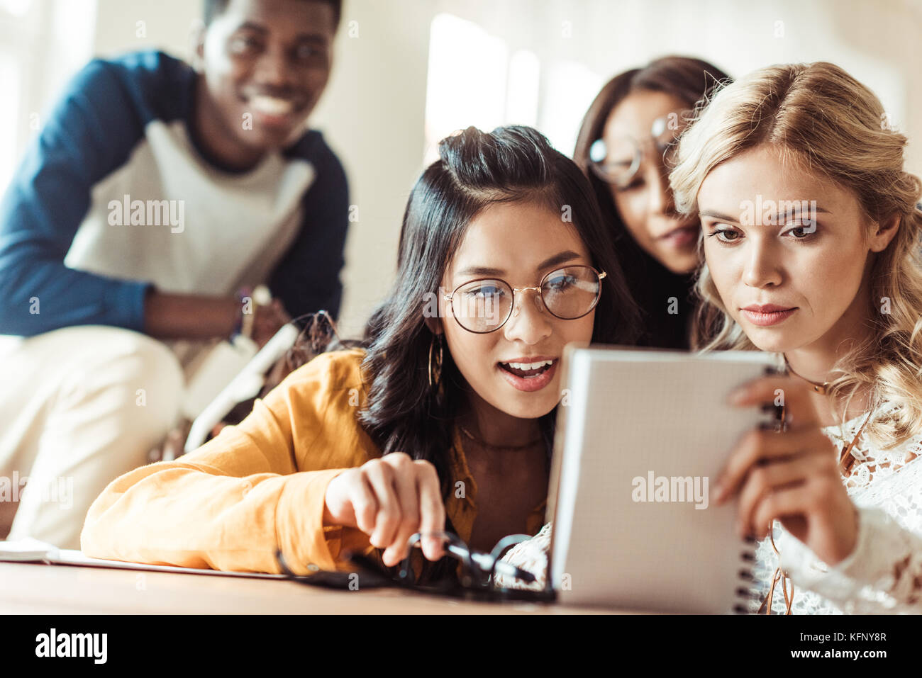 excited students looking at notebook Stock Photo - Alamy