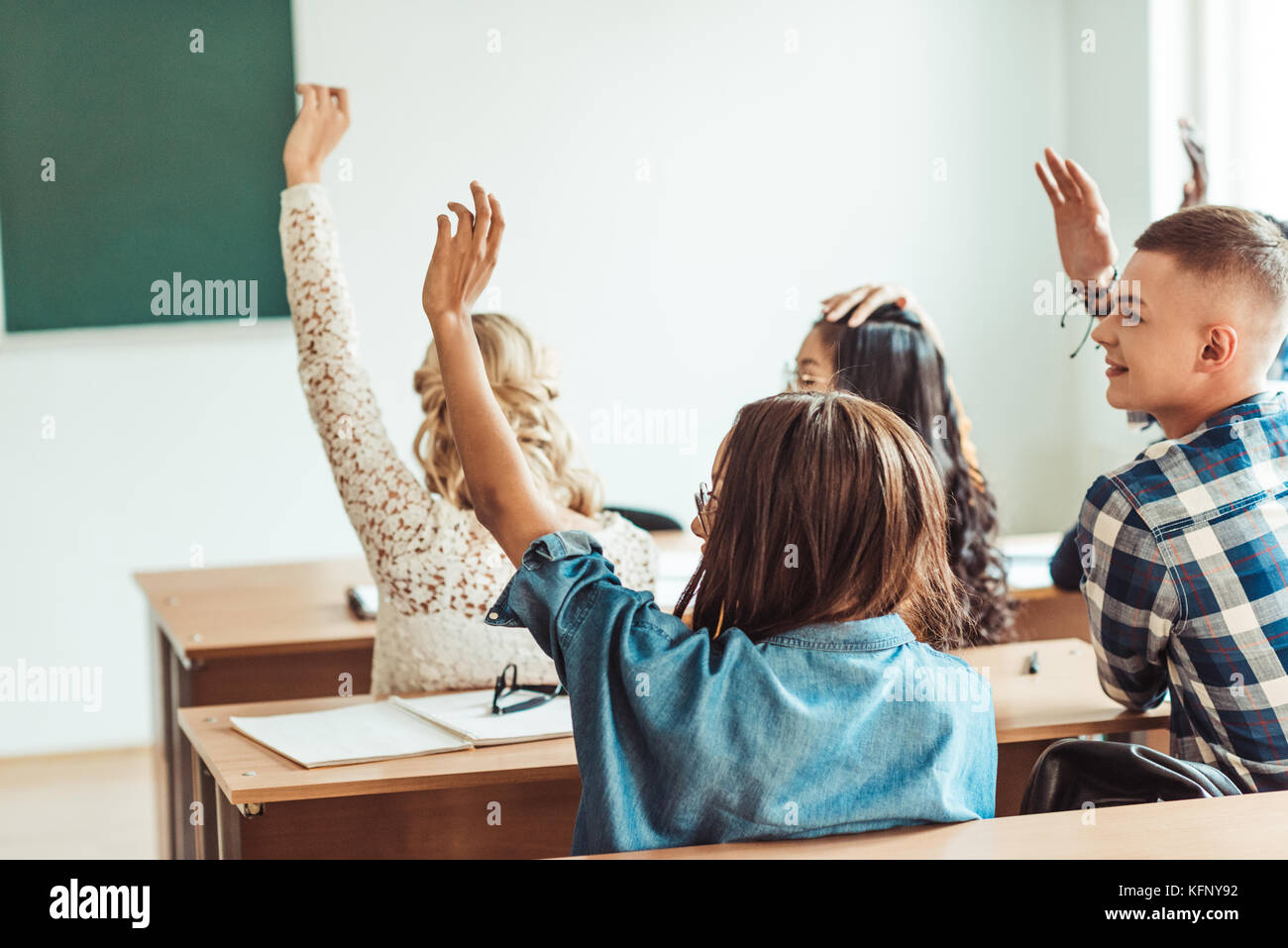 students raising hands in class Stock Photo - Alamy