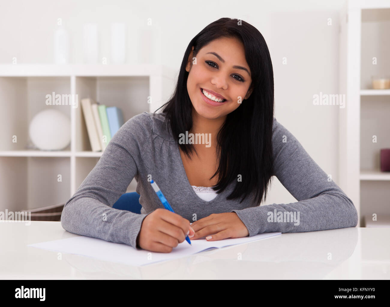 Portrait Of Young Happy Woman Writing On Paper Stock Photo - Alamy