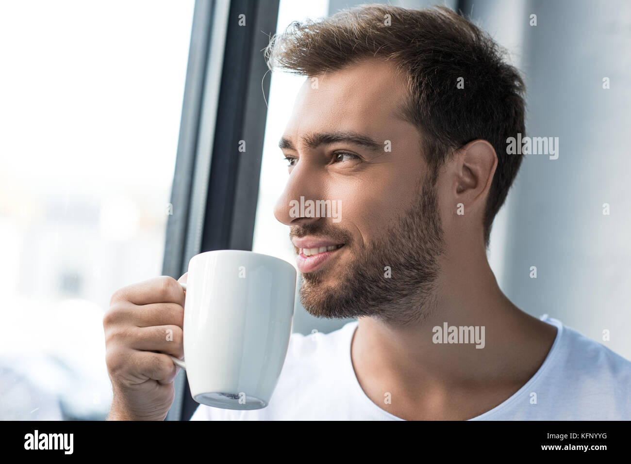 Smiling man drinking coffee Stock Photo - Alamy