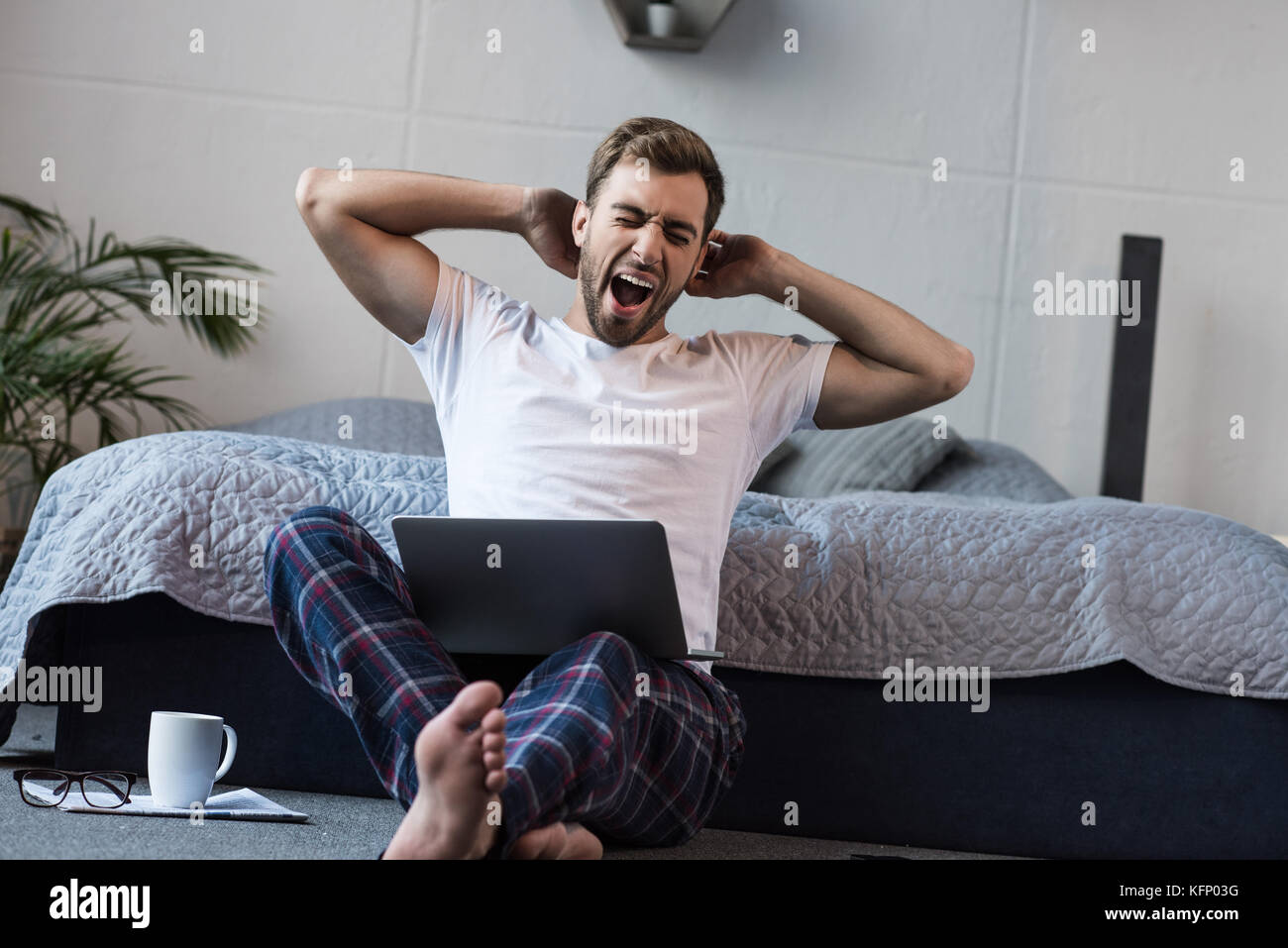 Sleepy man using laptop Stock Photo - Alamy