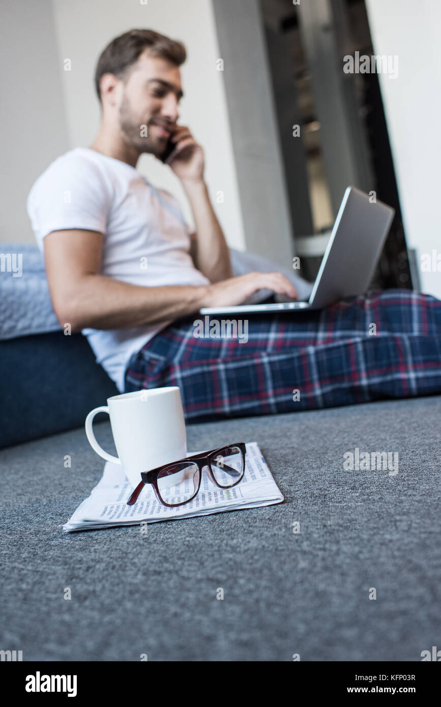 Man on phone using laptop Stock Photo - Alamy