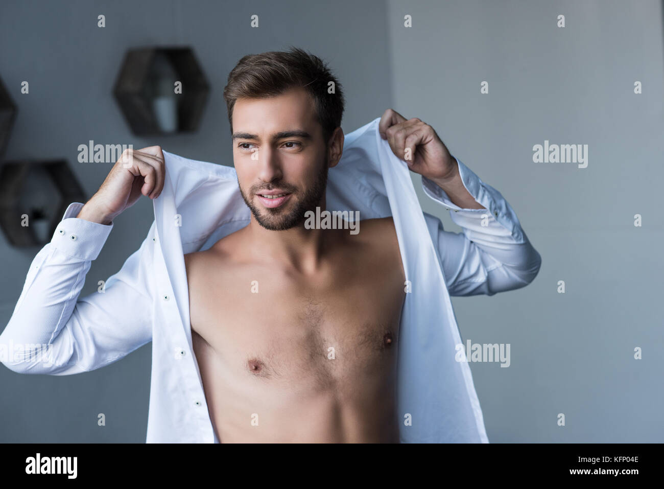 man putting on shirt Stock Photo - Alamy