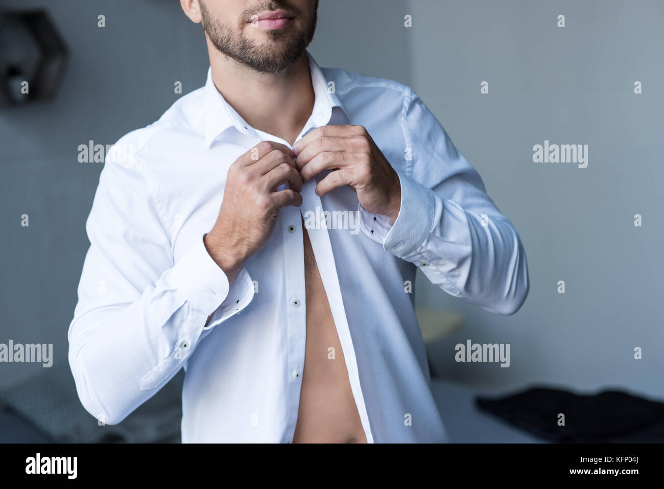 man buttoning up shirt Stock Photo - Alamy