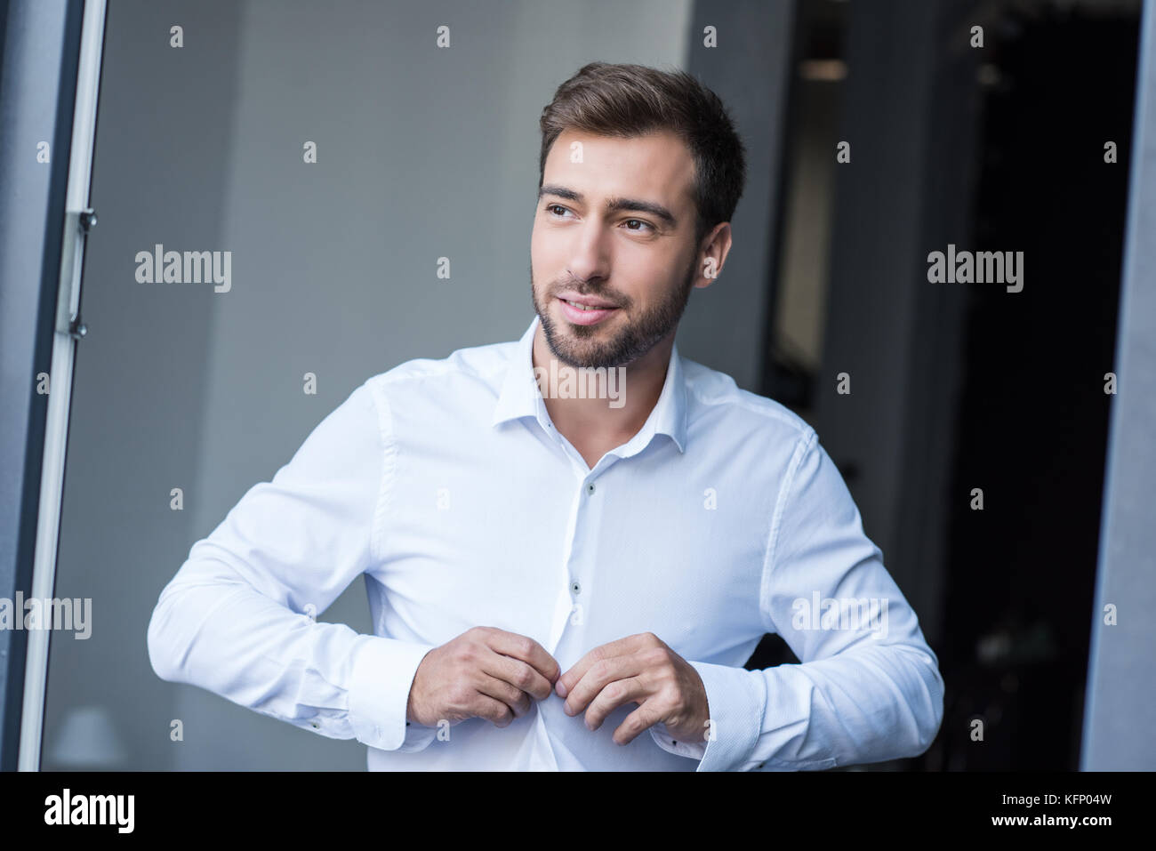 man buttoning up shirt Stock Photo - Alamy