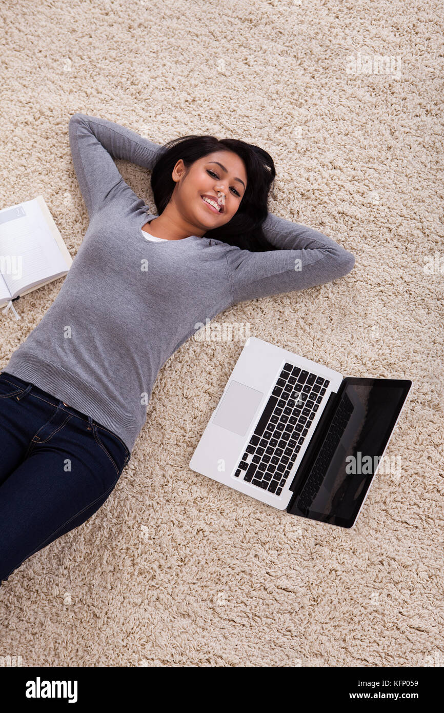 Top View Of Young Woman Lying On Carpet With Laptop Stock Photo - Alamy