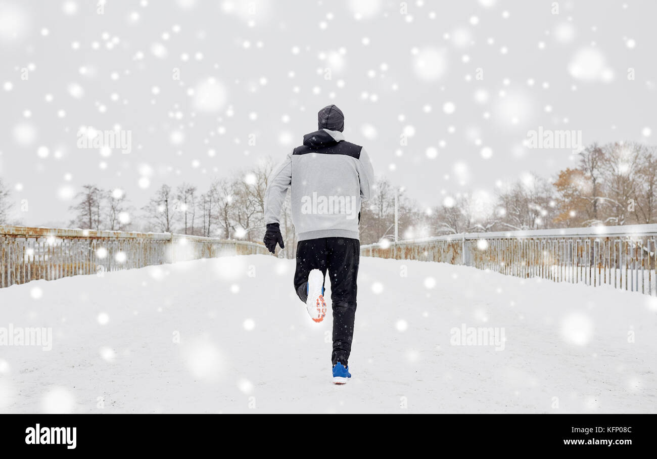 man running along snow covered winter bridge road Stock Photo - Alamy
