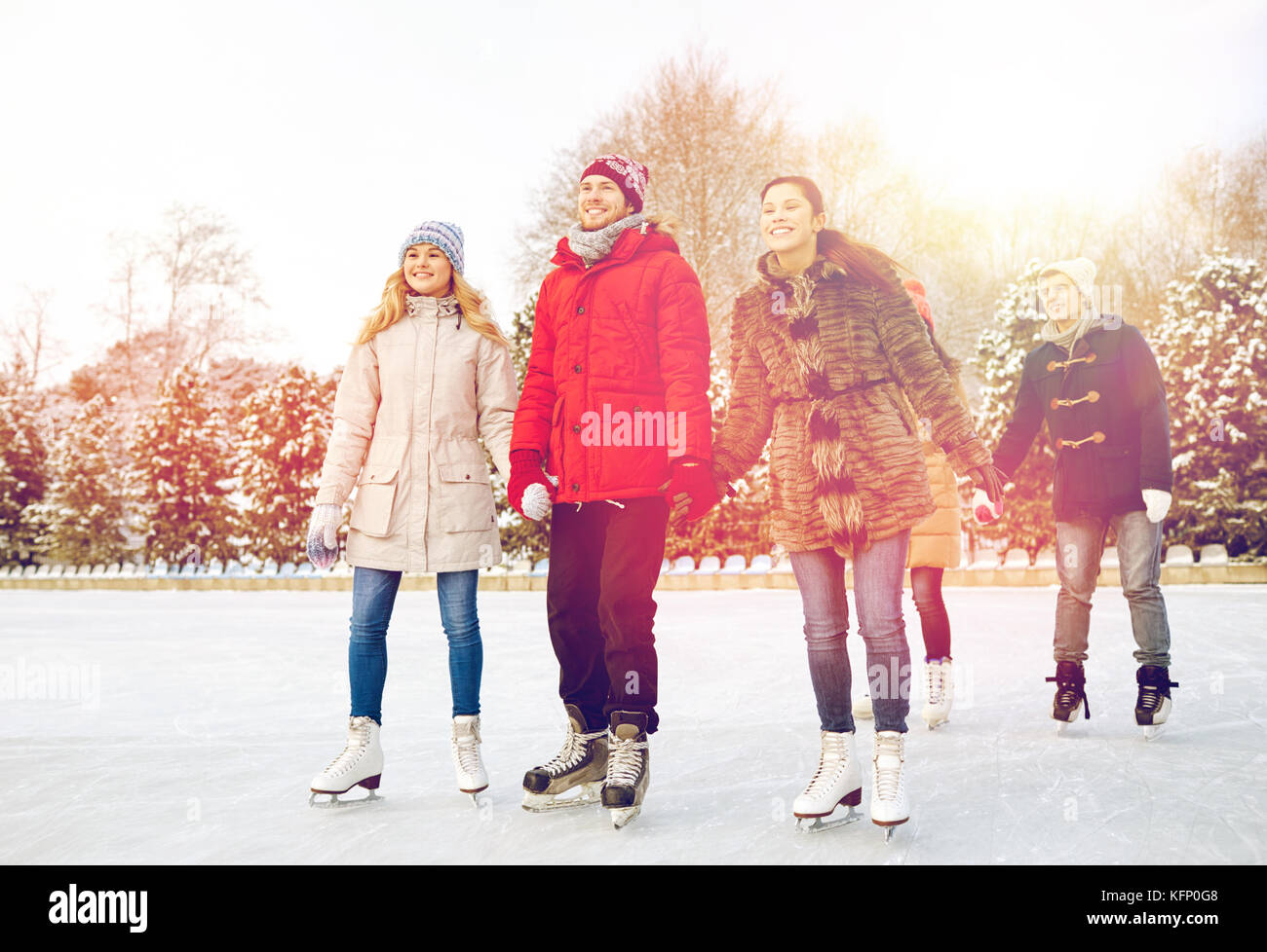 happy friends ice skating on rink outdoors Stock Photo - Alamy