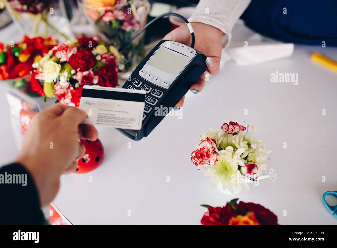 Man paying for flowers with his debit card. Credit card payment Stock ...