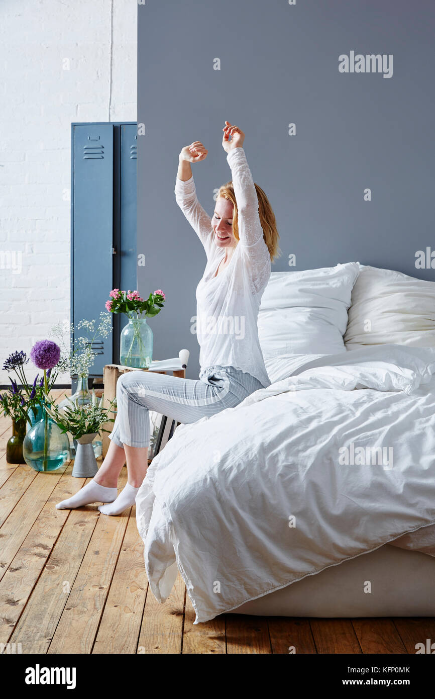 young attractive red haired woman enjoys getting up in the morning ...