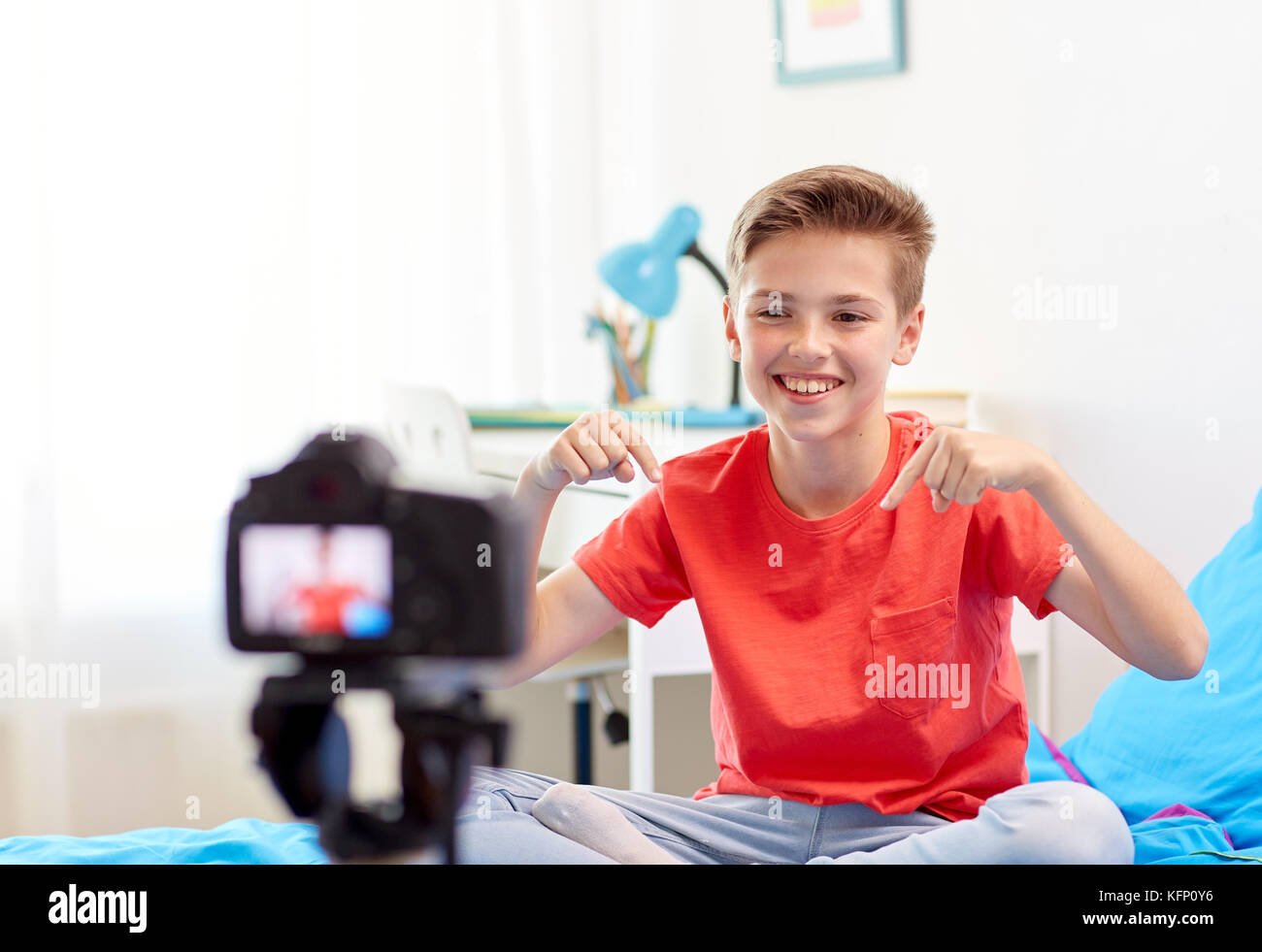 happy boy with camera recording video at home Stock Photo - Alamy