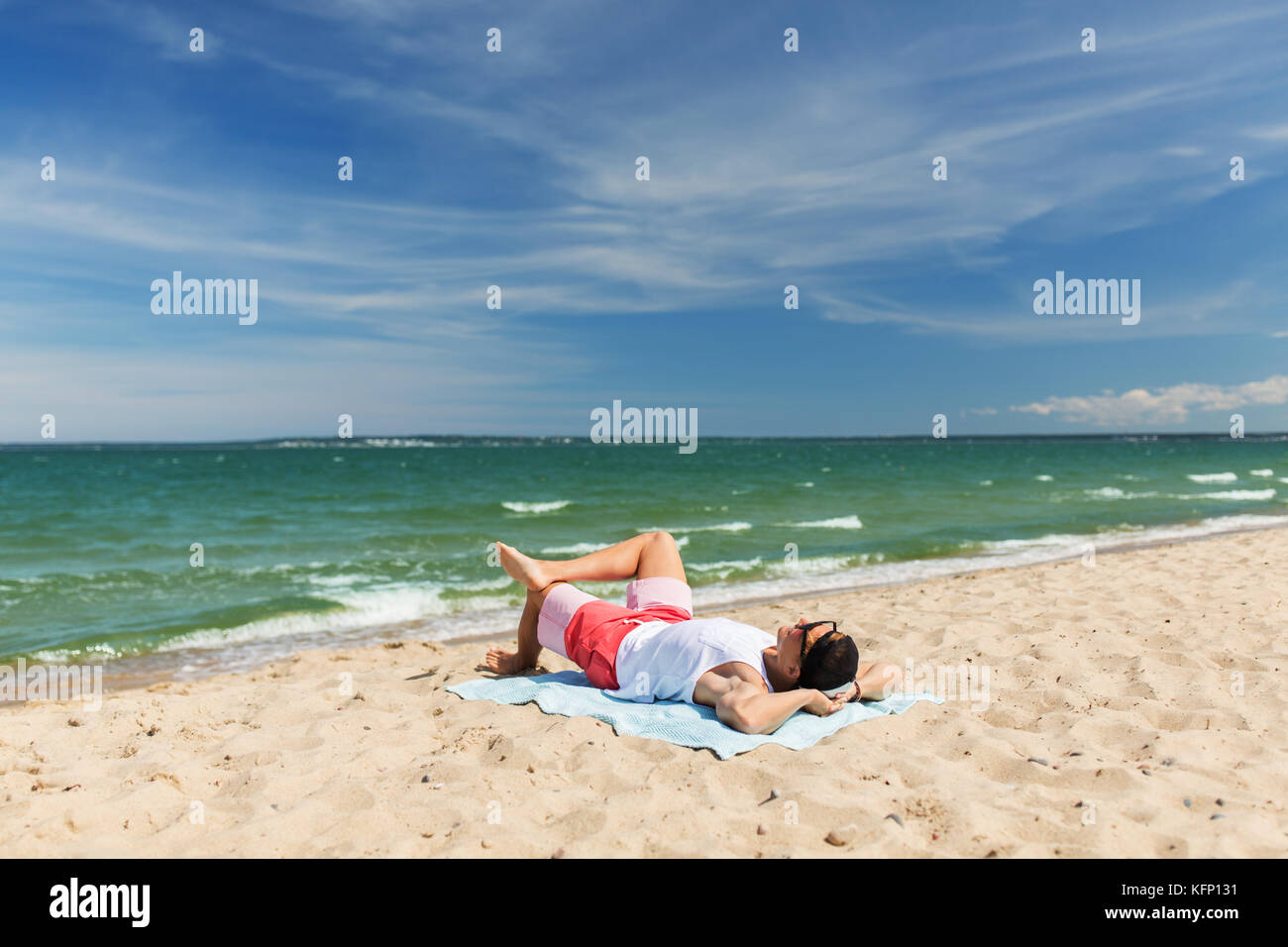 happy smiling young man sunbathing on beach towel Stock Photo - Alamy