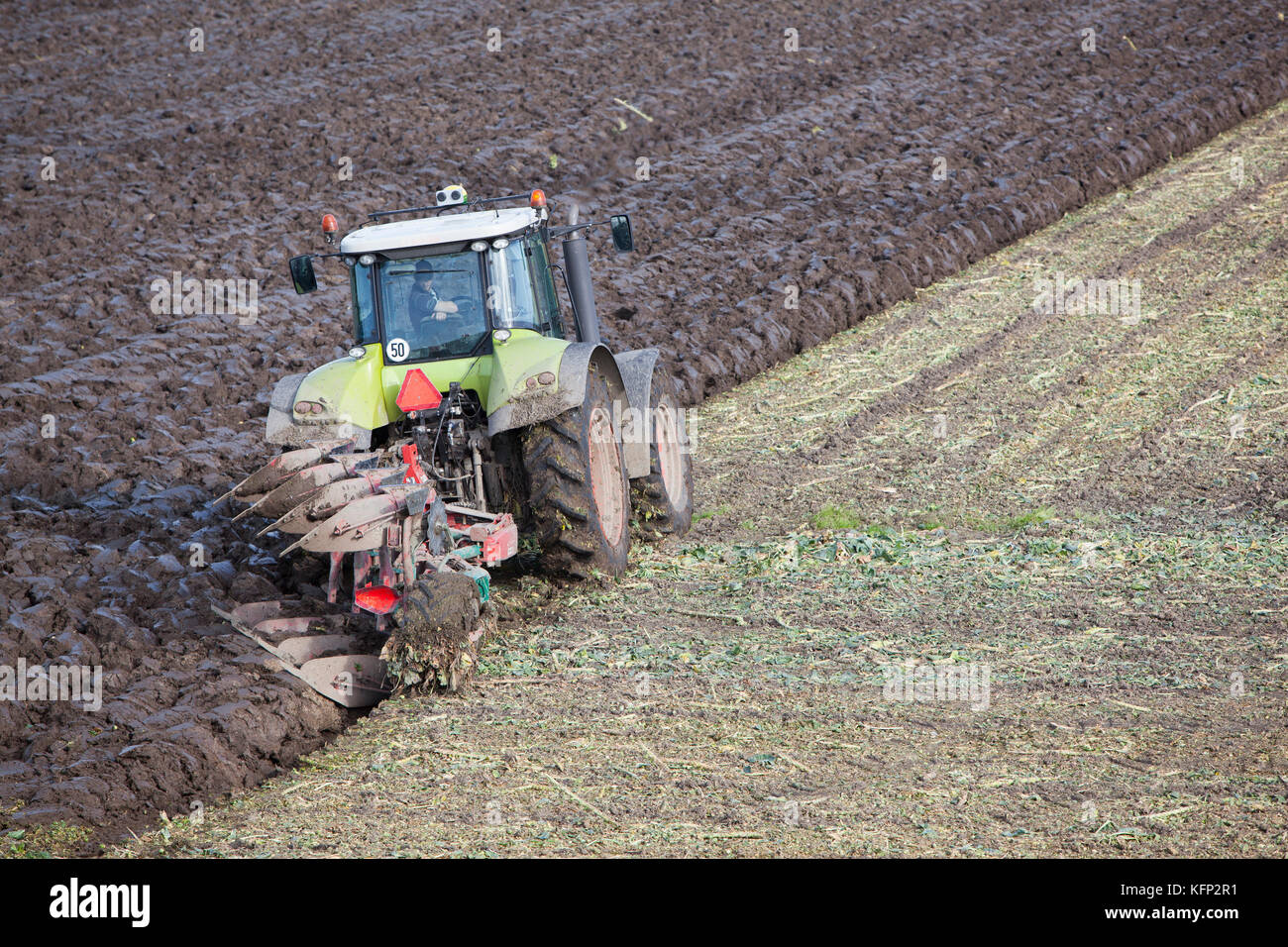 tractor and plow at work on field in the dutch province of flevoland in ...