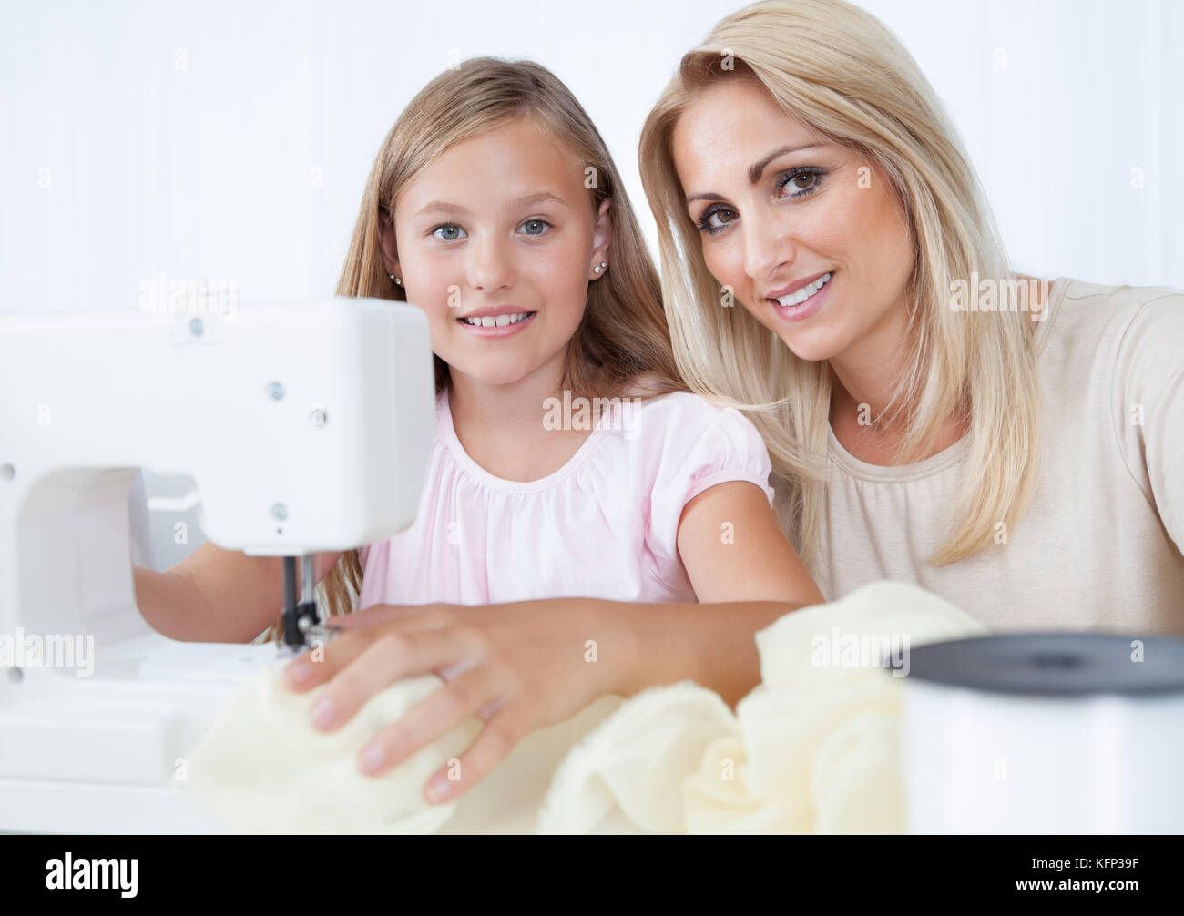 Portrait Of A Beautiful Young Girl Sewing With Her Mother At Home Stock ...