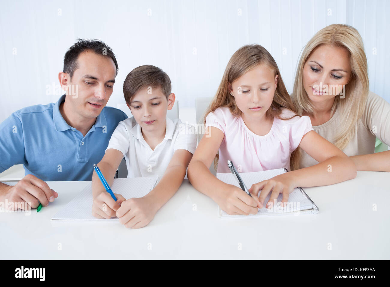 Parents Helping Their Children With Their Homework At Home Stock Photo ...