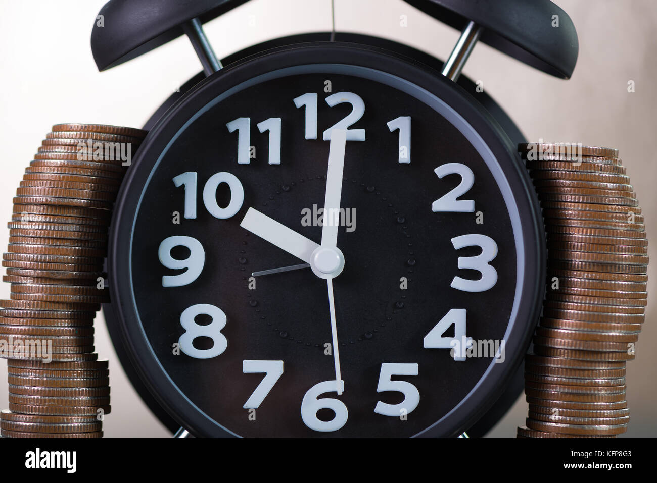 Alarm clock and piles of coin on working table, time for savings money ...