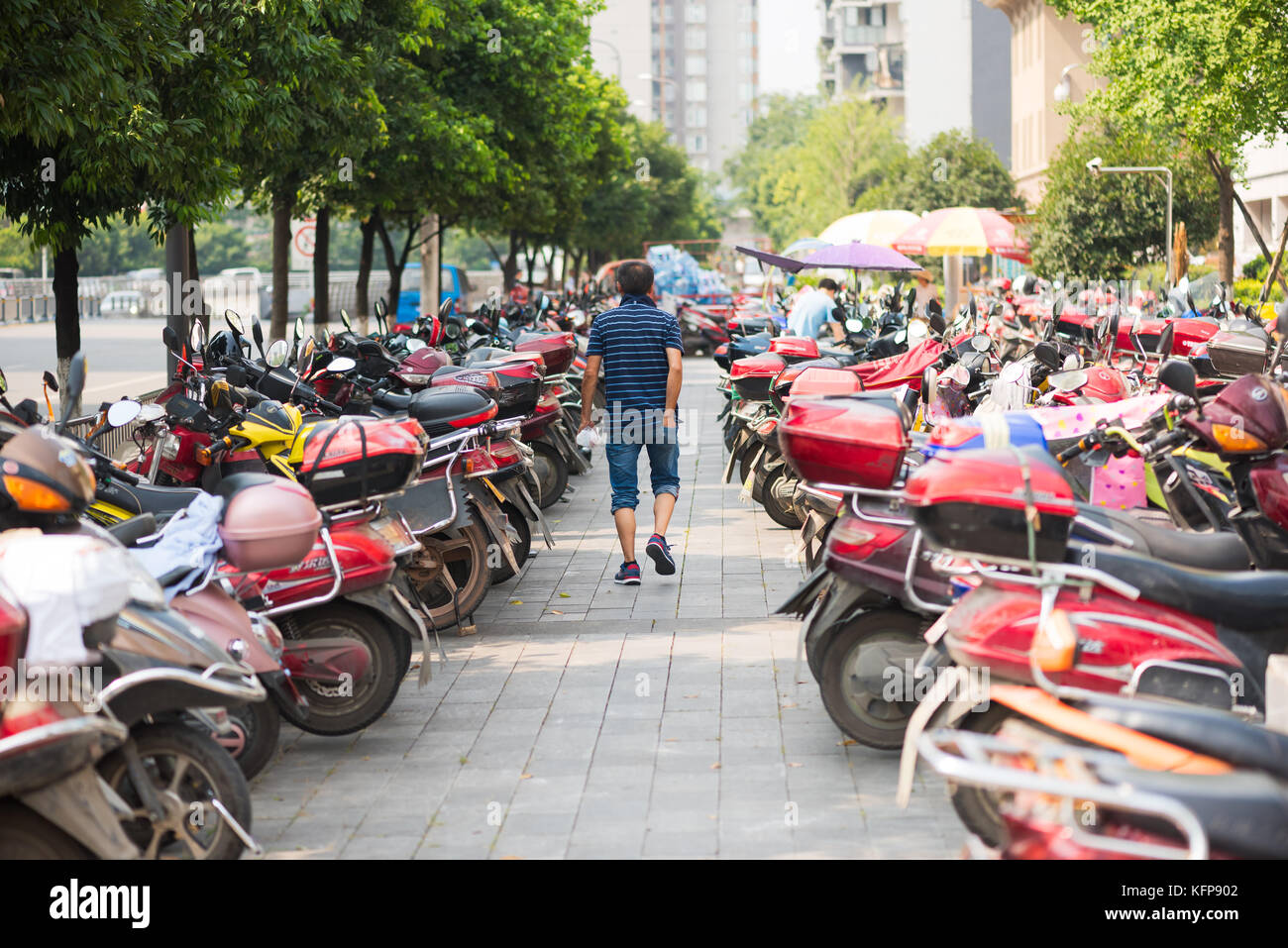 Man walking in an electric scooter parking in Chengdu Stock Photo - Alamy
