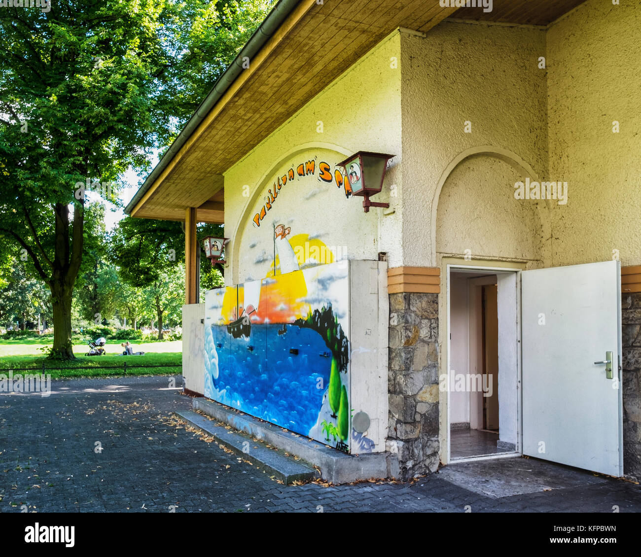 Berlin , Alt-Tegel.Colourful toilet entrance with wall art and lamps ...
