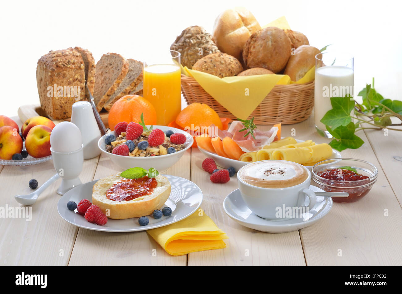 Colorful breakfast with cappuccino, fruit, fresh orange juice, ham ...