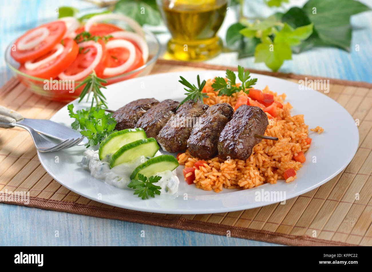 Greek meat balls with paprika rice and tsatsiki, in the background ...
