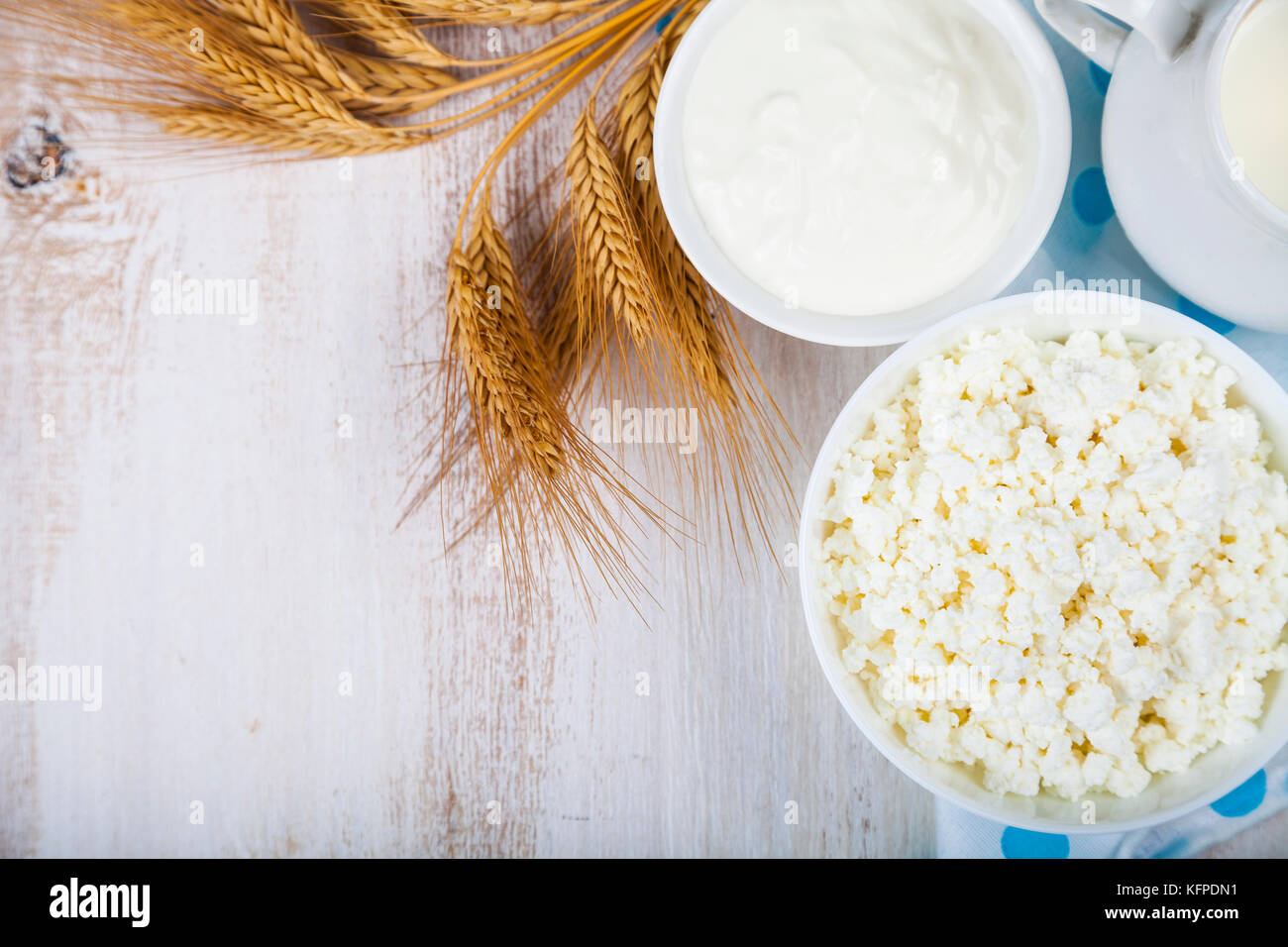 Cottage cheese,ear, sour cream and milk on a wooden table, top view ...